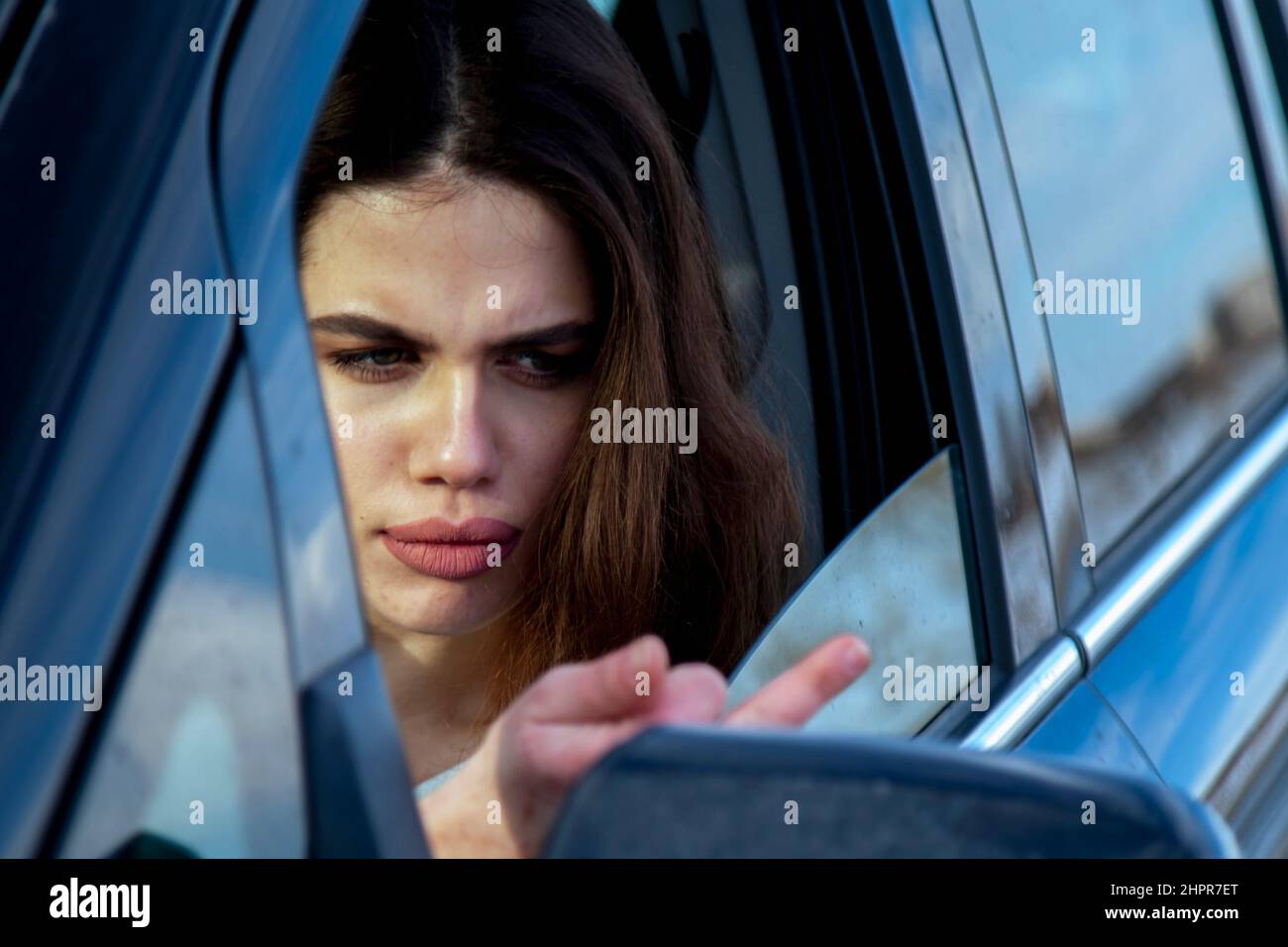 Aggressive driving. Female angry driver showing middle finger gesture ...