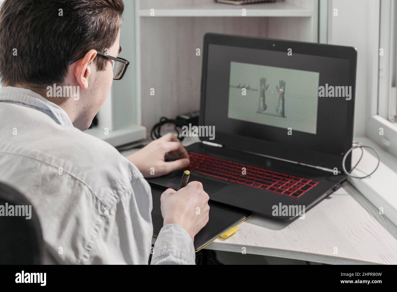 man creates video games. a designer creates a 3d model on his laptop ...