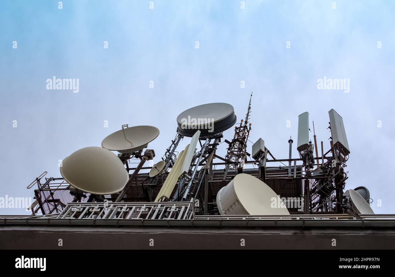Many antennas transmitters and receivers for television and mobile phones broadcasting signal ...