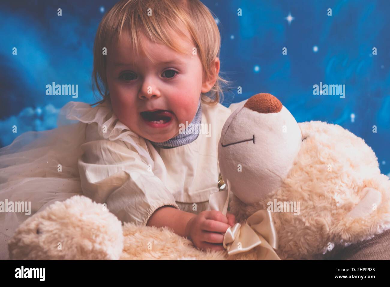 Little beautiful child girl huggs a teddy bear before bedtime ...