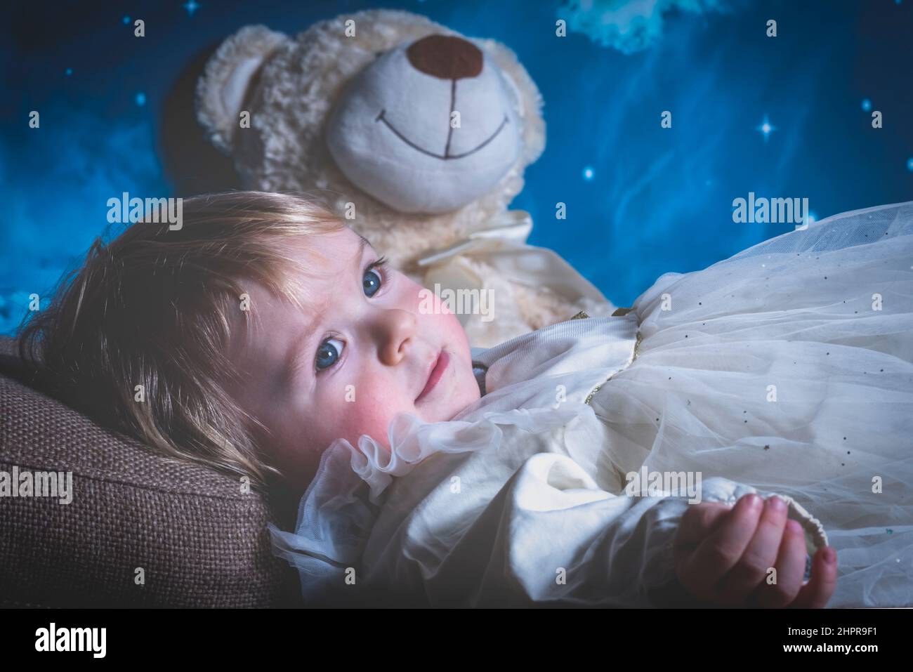 Cute child girl falling asleep with her teddy bear. Happy carefree ...