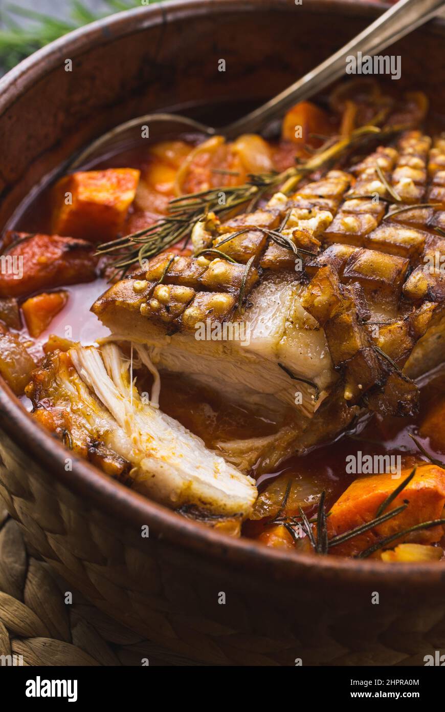 Big slab of crispy roasted pork belly in a clay dish with sweet ...