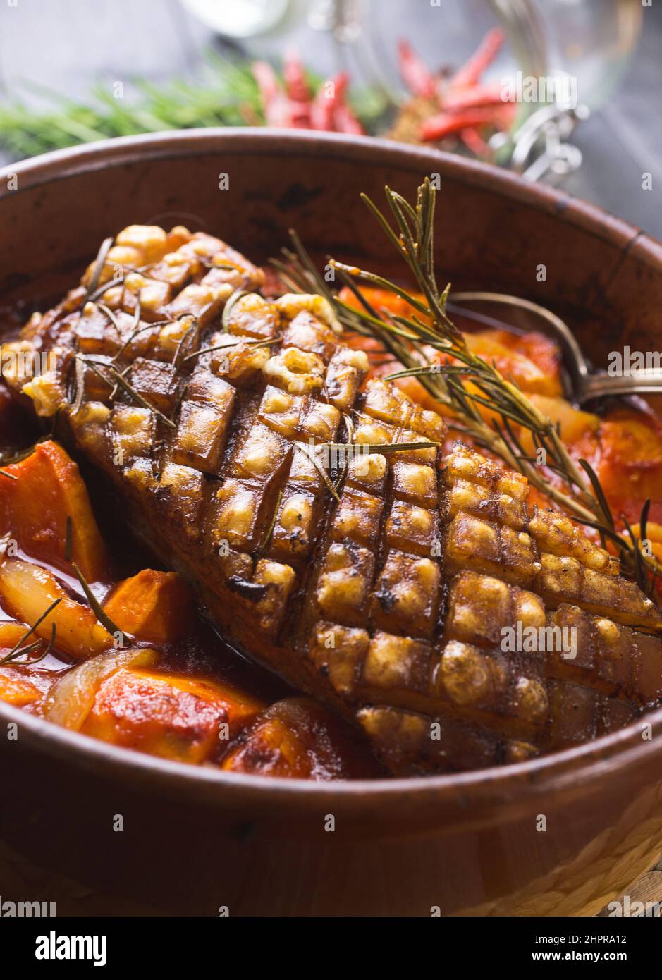 Big slab of crispy roasted pork belly in a clay dish with sweet ...