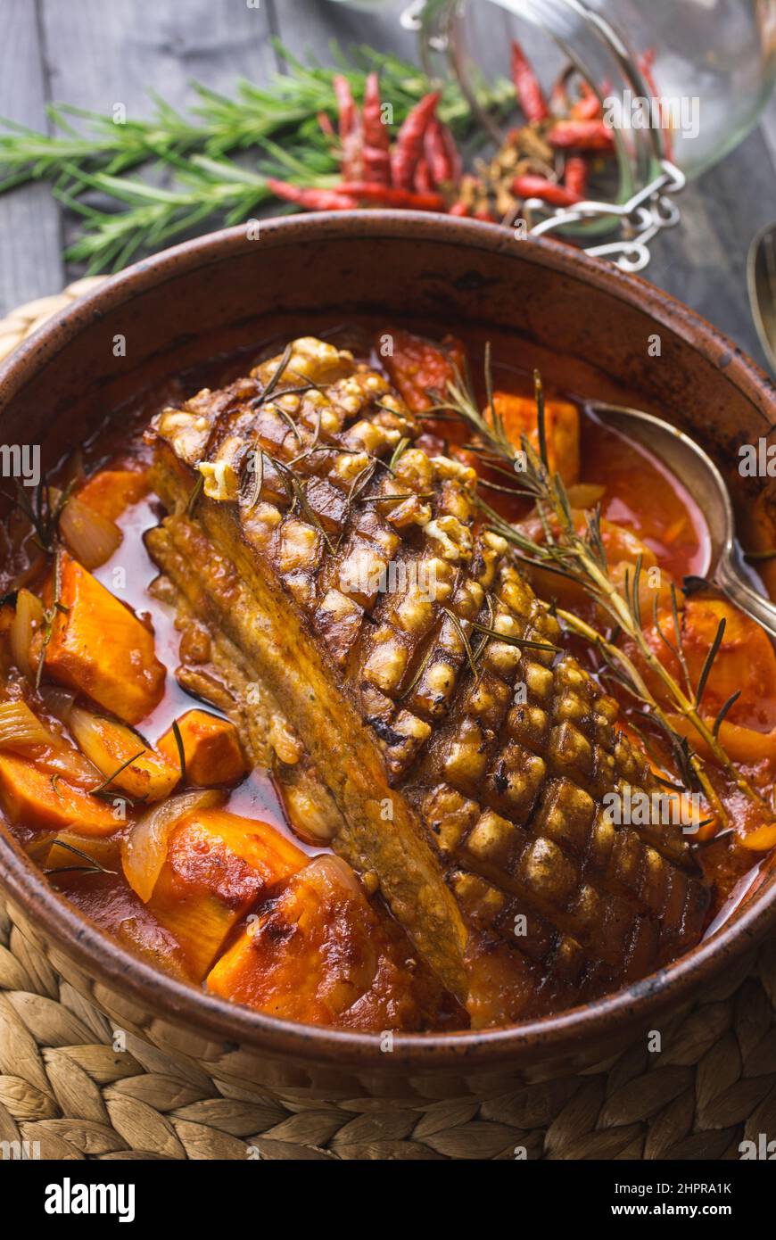 Big slab of crispy roasted pork belly in a clay dish with sweet ...