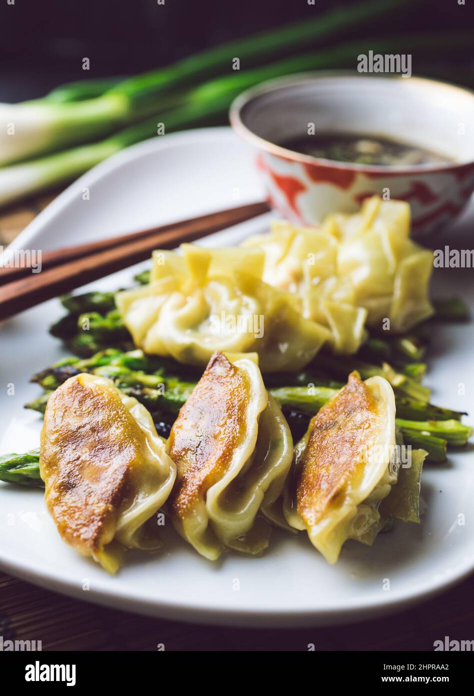 A plate full of crispy gyoza dumplings filled with pork and served with ...
