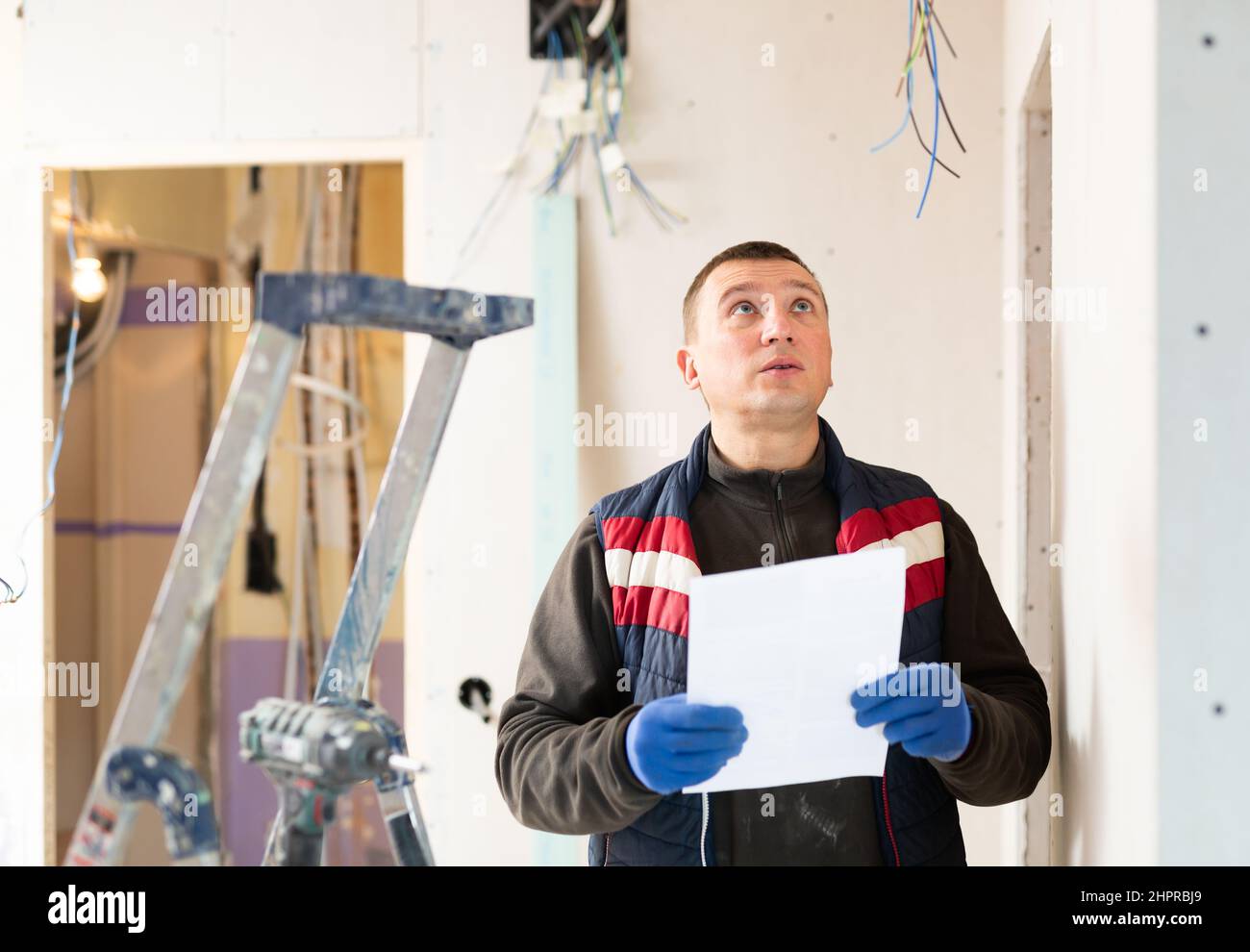 Professional electrician reads electrical wiring plan Stock Photo - Alamy