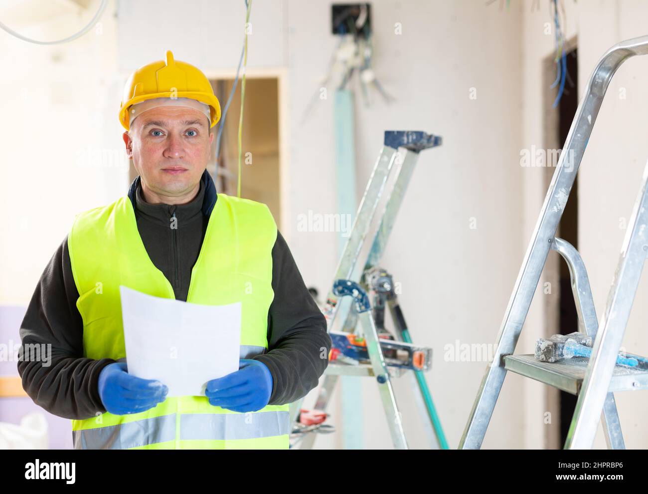 Builder handyman examining room and planning construction works Stock ...