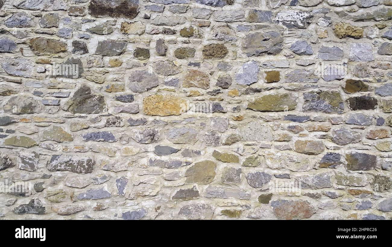The stone wall. Front view and close up. Wall made of different colored ...