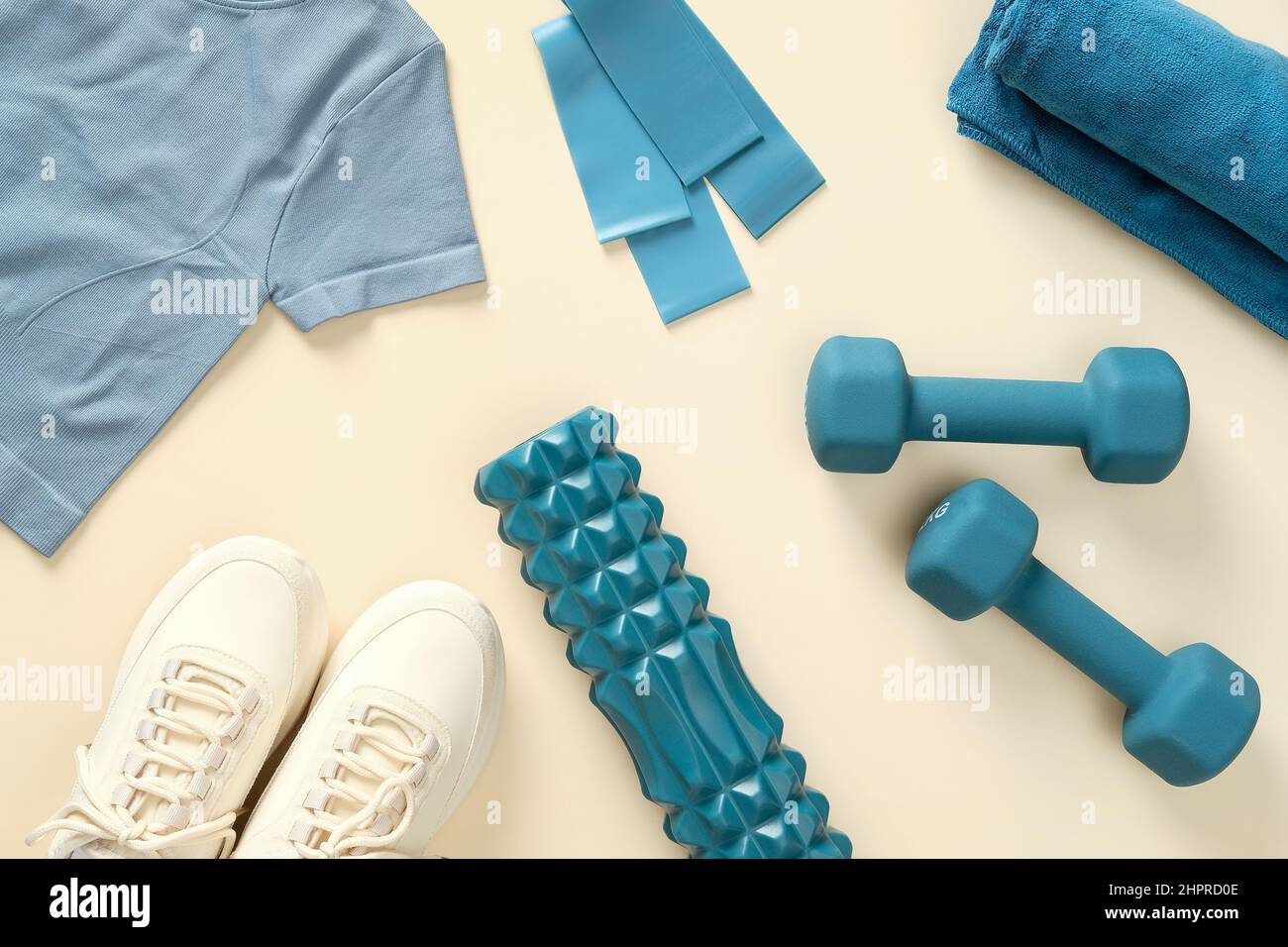 Feminine sport workout equipment and stuff on beige table, top view ...