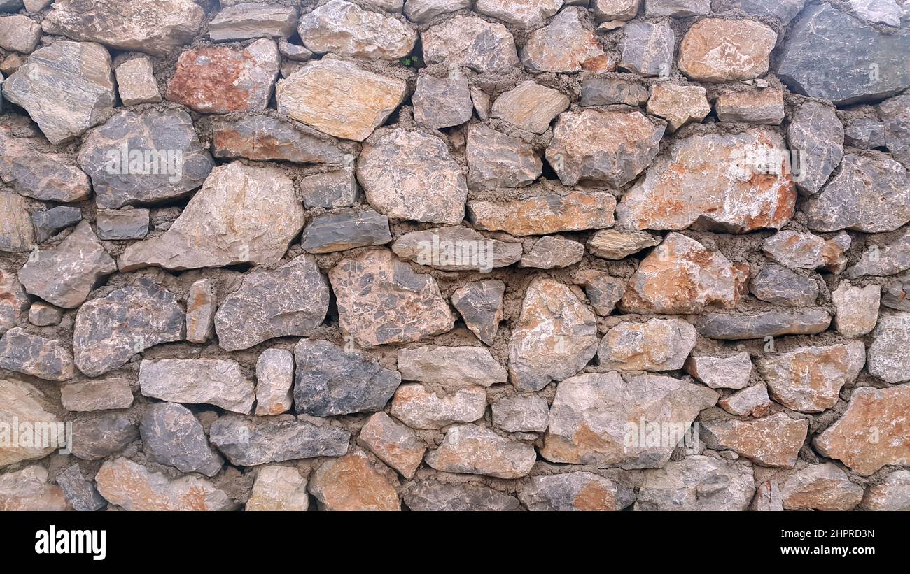 Stone wall. An old handmade stone wall. Front view Stock Photo - Alamy