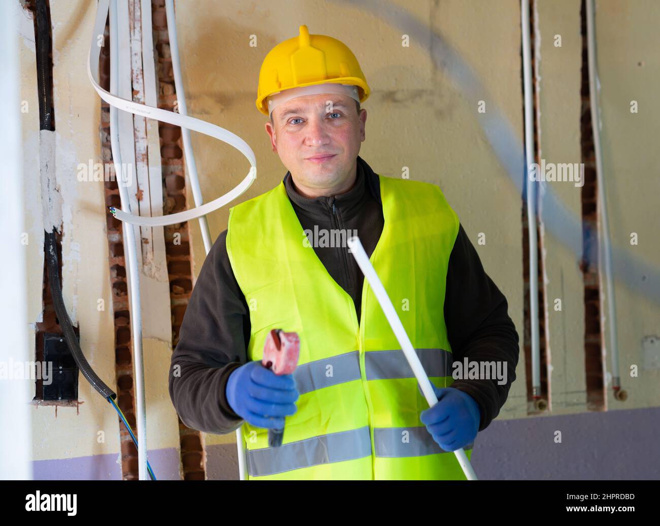 Plumber prepares plastic pipes for installation in building under ...