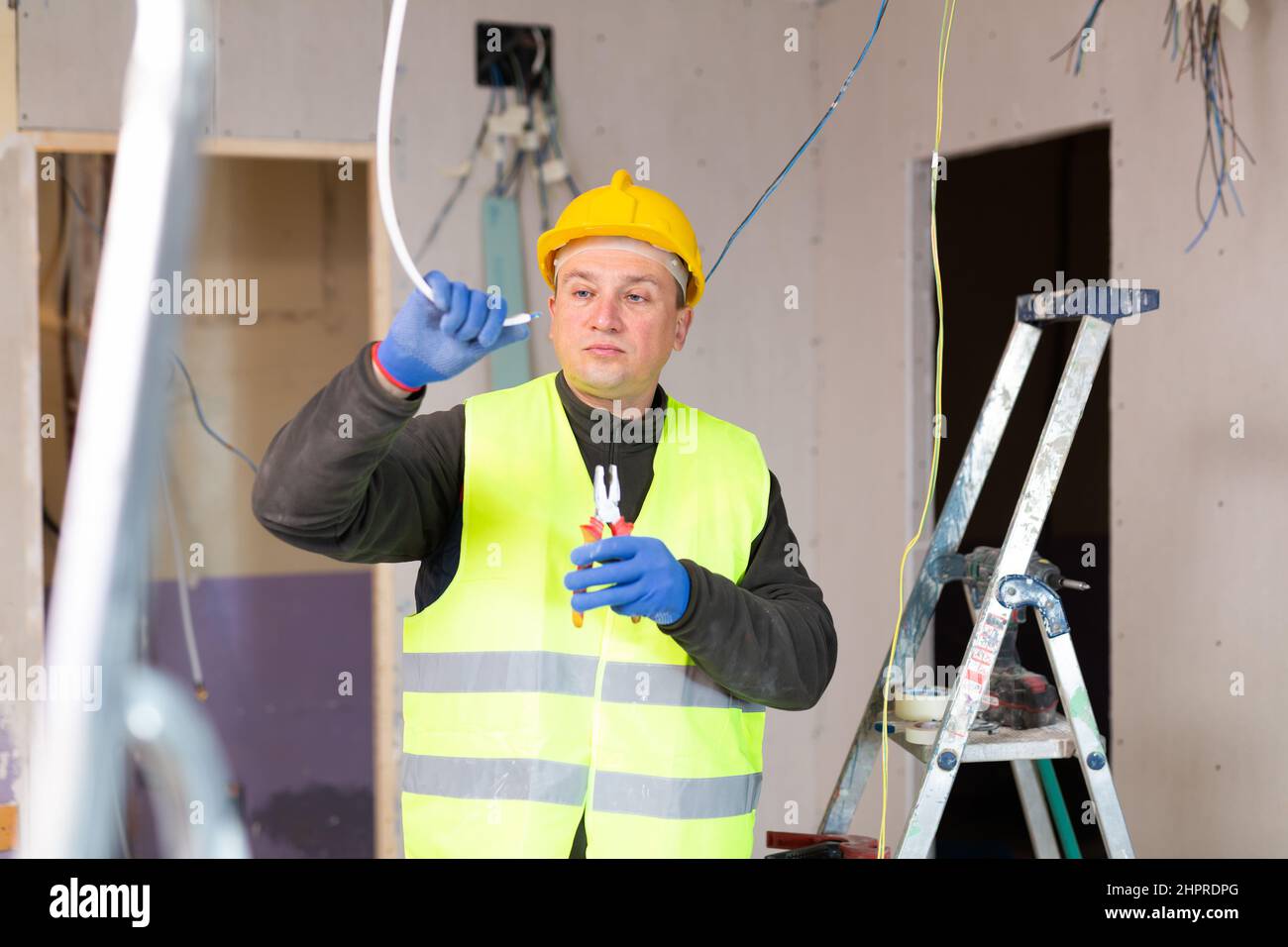 Worker repairing wires while installing electricity Stock Photo - Alamy