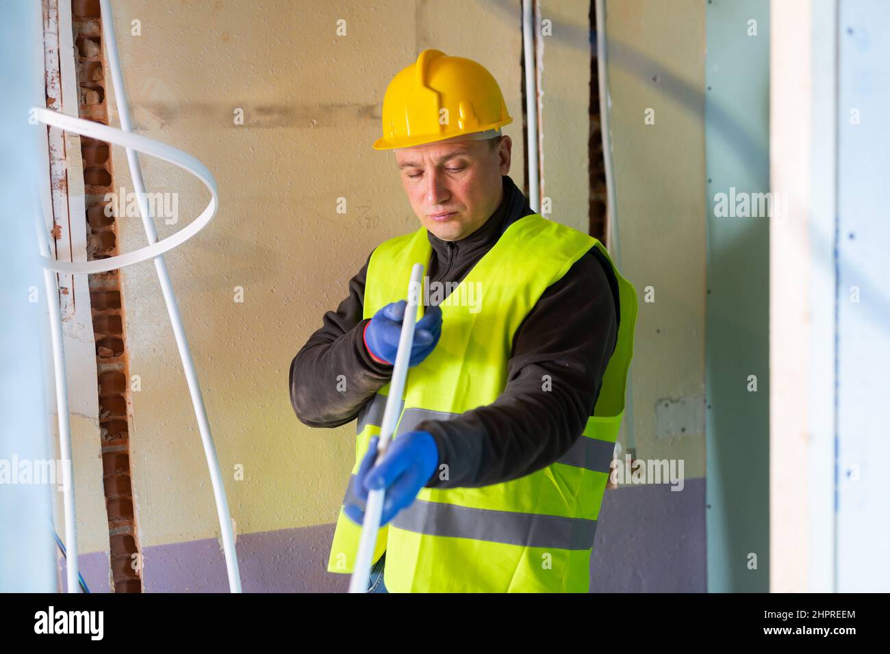 Electrician looking through cable duct Stock Photo - Alamy