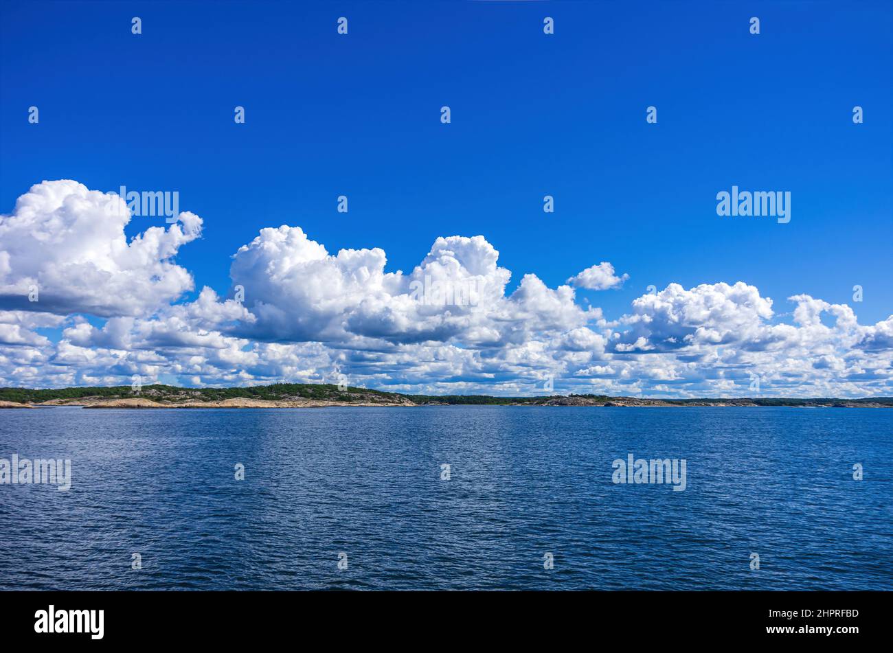 Skerries and coastline under a bright cloudy blue sky in the Koster ...