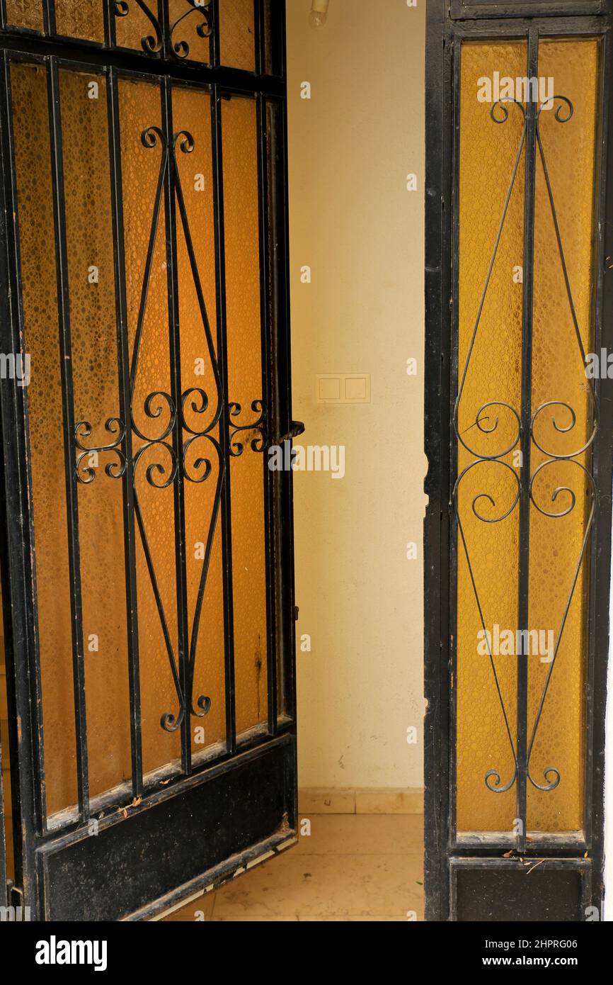 Black forged metal door with yellow glass Stock Photo - Alamy