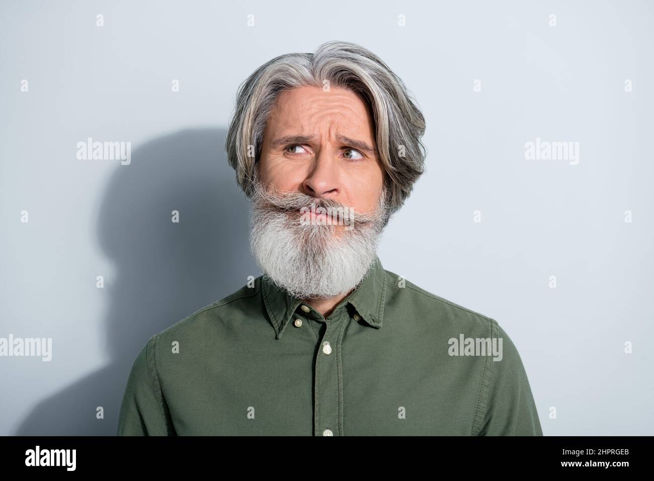 Portrait of attractive focused grey-haired man overthinking copy space ...