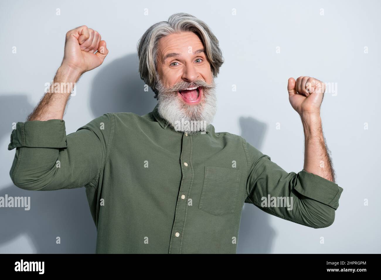Portrait of attractive cheerful grey-haired man dancing celebrating ...