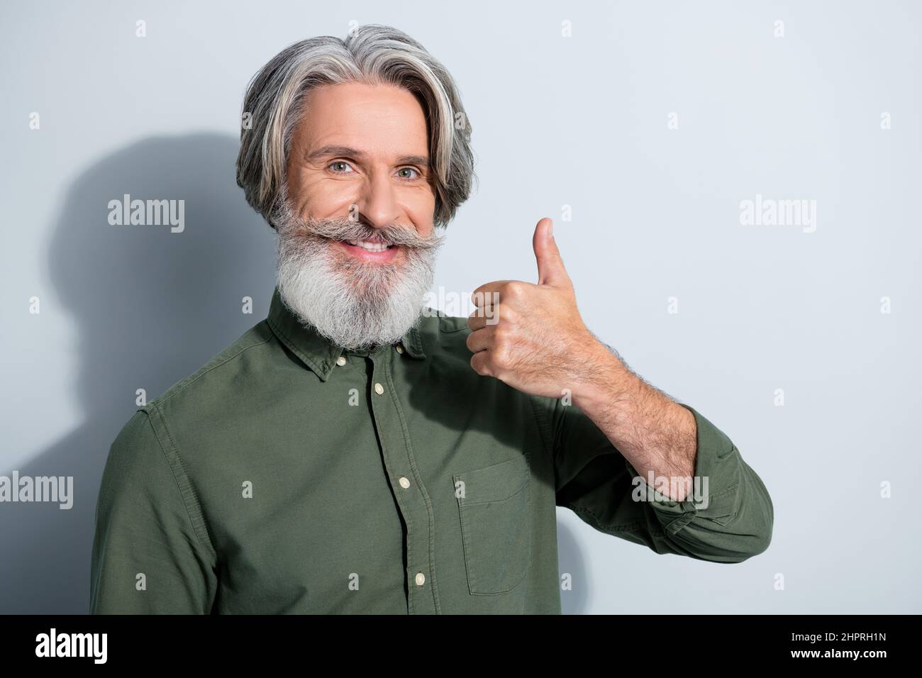 Portrait of attractive cheerful grey-haired man showing thumbup ad ...