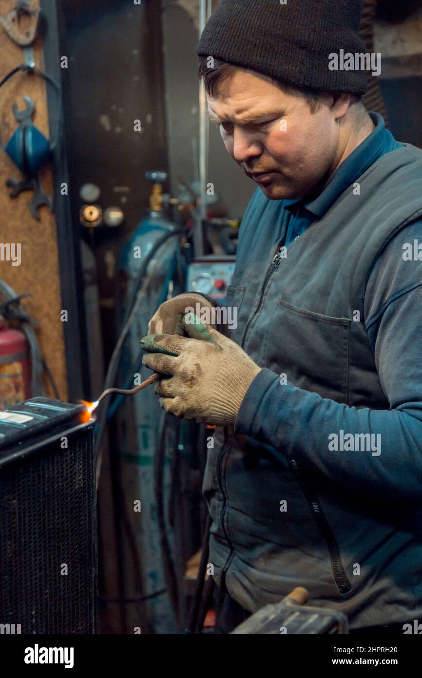 Welding a large car radiator with a gas torch Stock Photo - Alamy