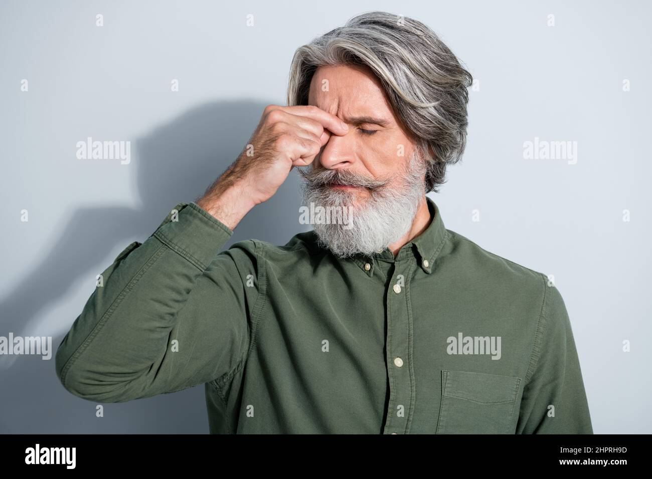 Portrait of attractive tired depressed sick grey-haired man touching ...