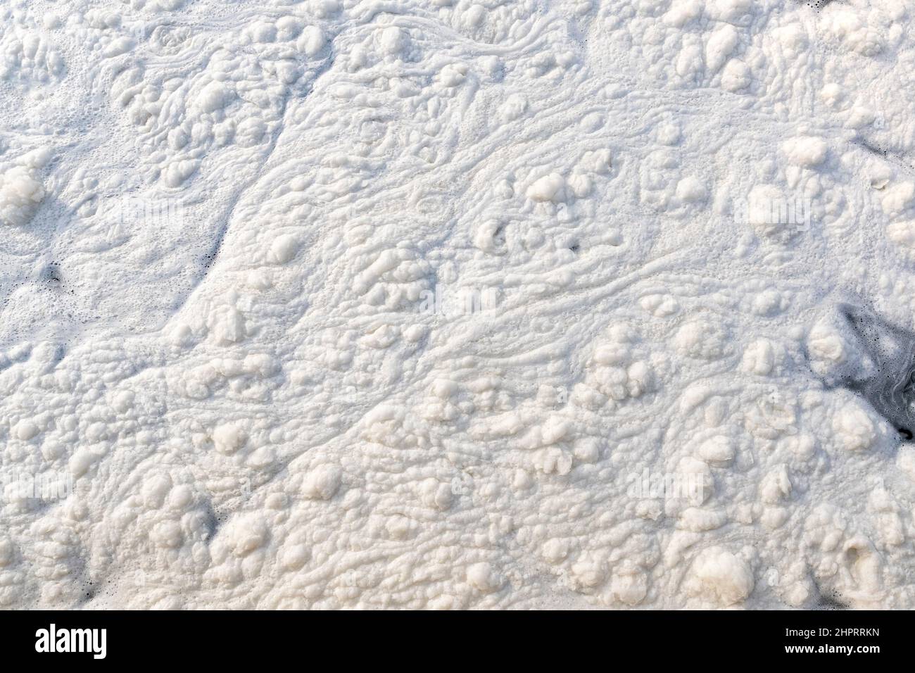 White foam background. Pollution of a river caused by surfactants ...
