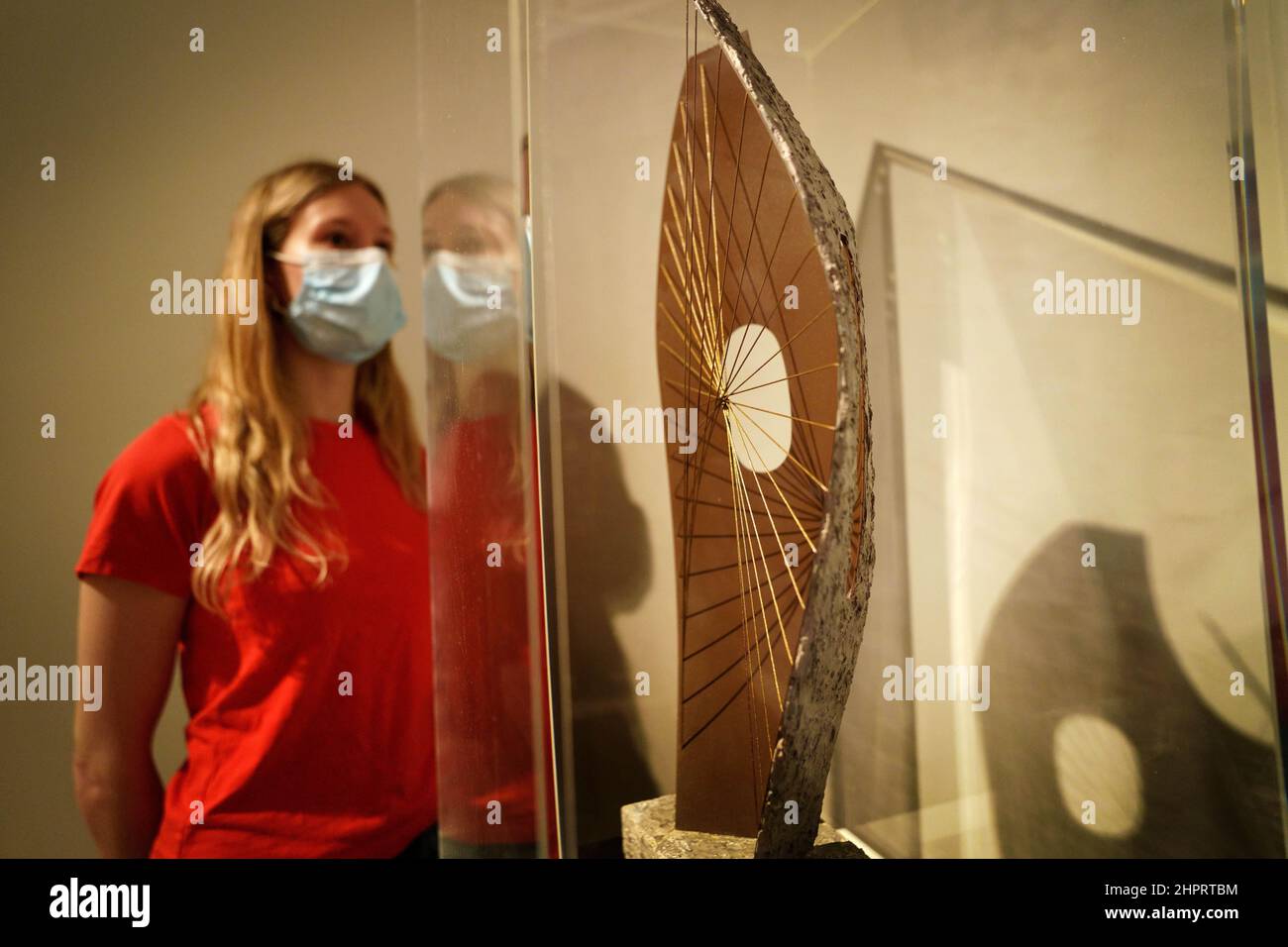 A gallery assistant poses with Winged Figure, 1957, by Barbara Hepworth ...