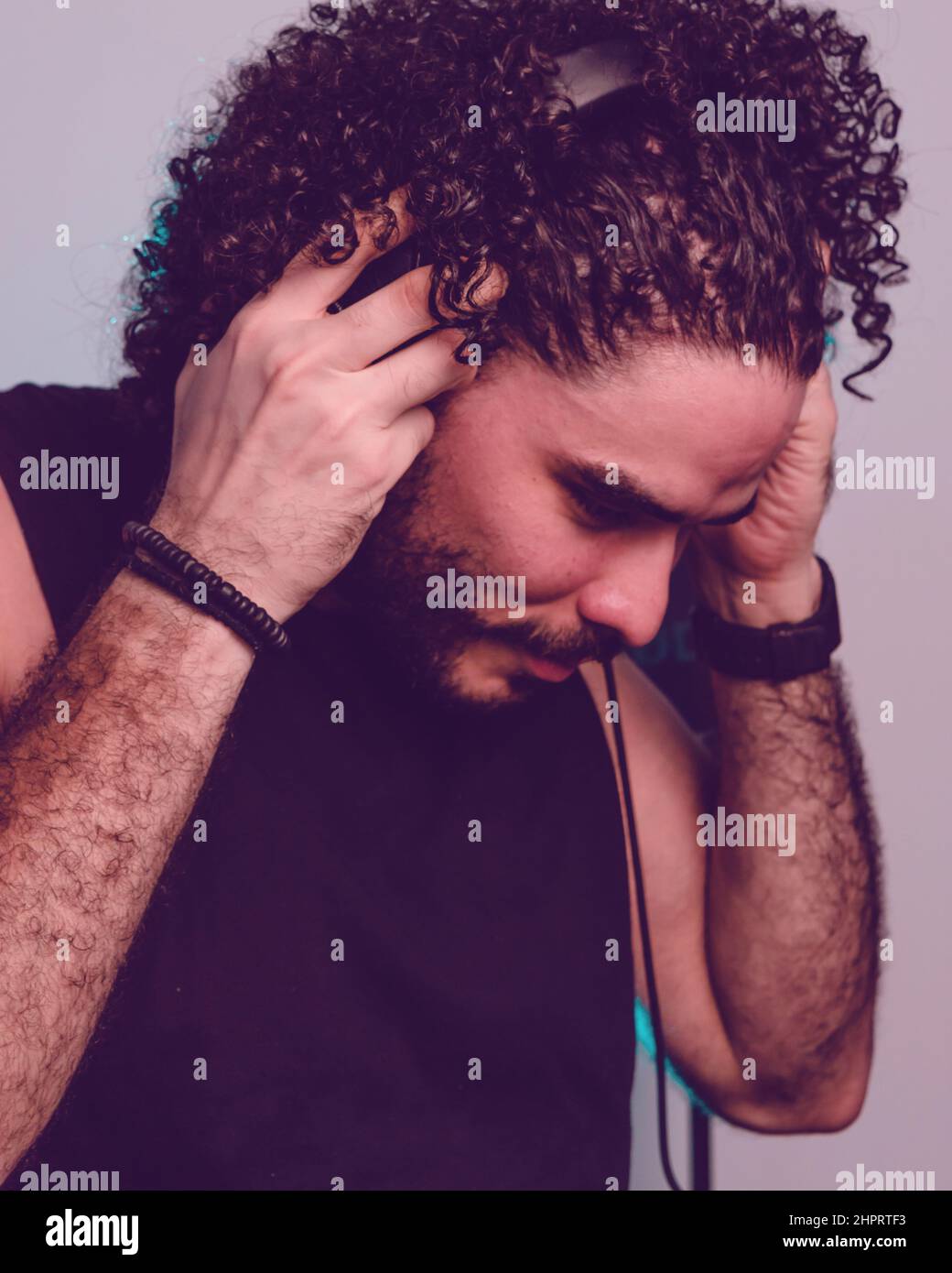 vertical image of caucasian man in home studio taking off headphones ...