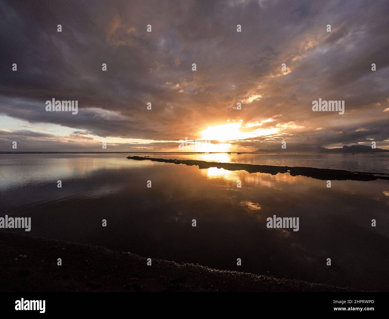 Sunset from a black sand beach in Tahiti Stock Photo - Alamy
