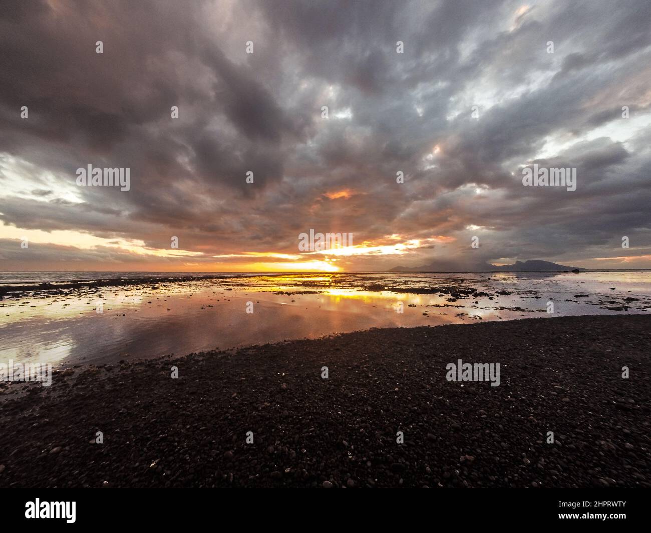 Sunset from a black sand beach in Tahiti Stock Photo - Alamy
