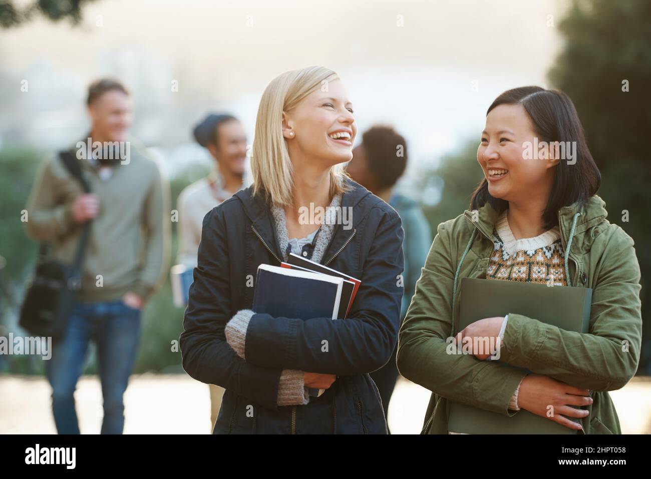 College life. Shot of a college students between classes on the campus ...