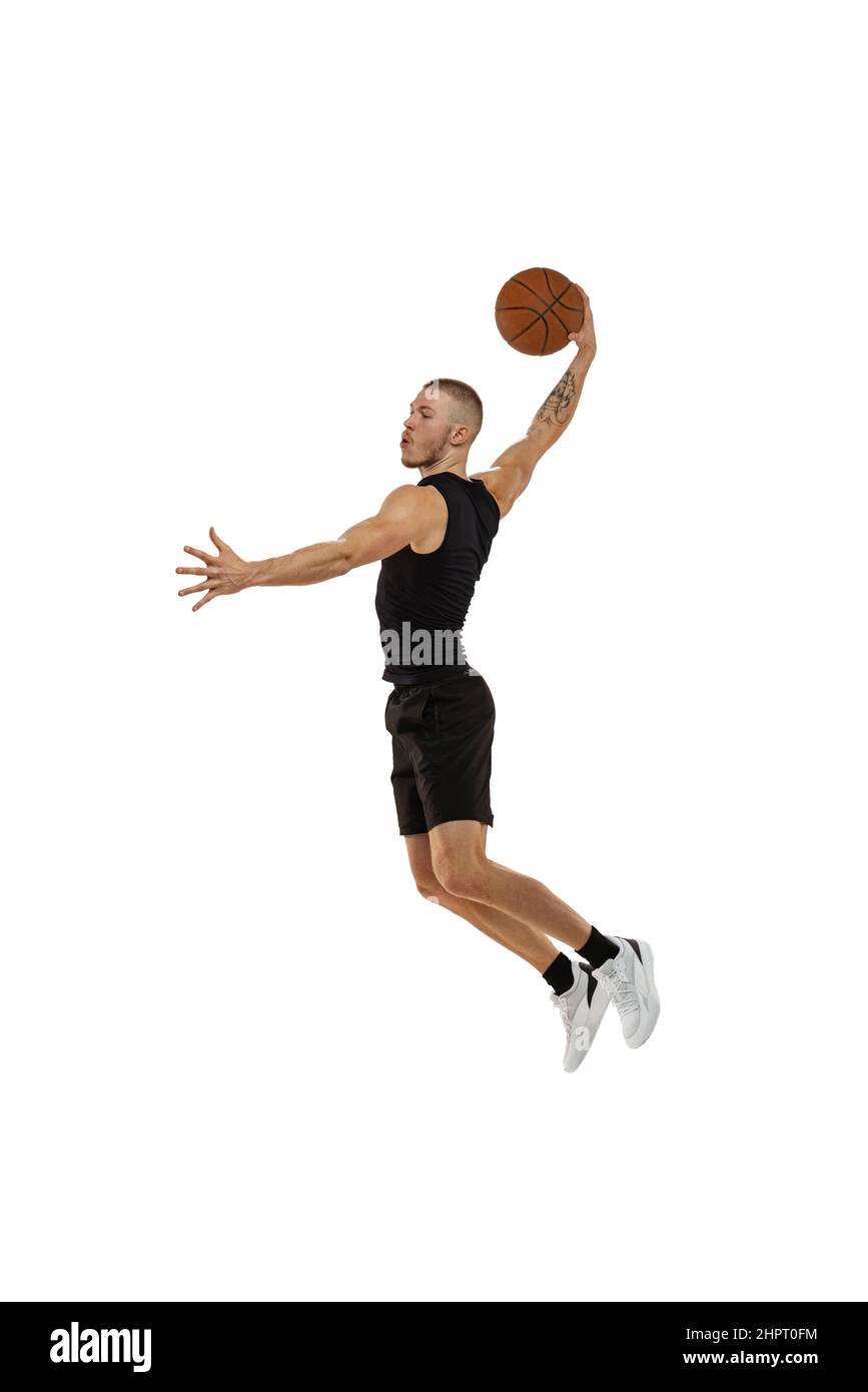 Flying. Portrait of basketball player jumping with ball isolated on ...
