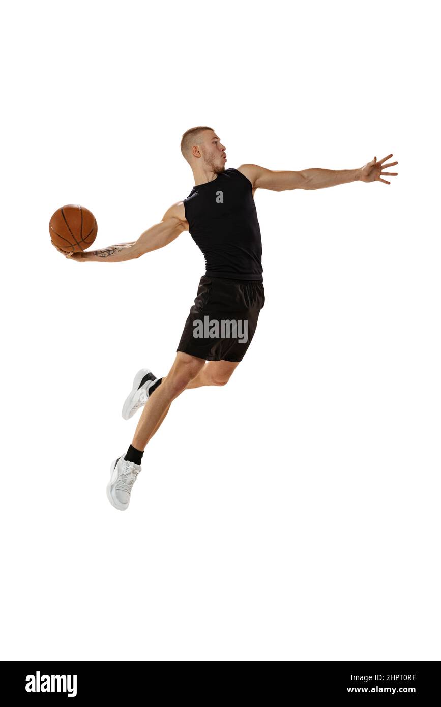 Dynamic portrait of muscled man, basketball player jumping with ball ...