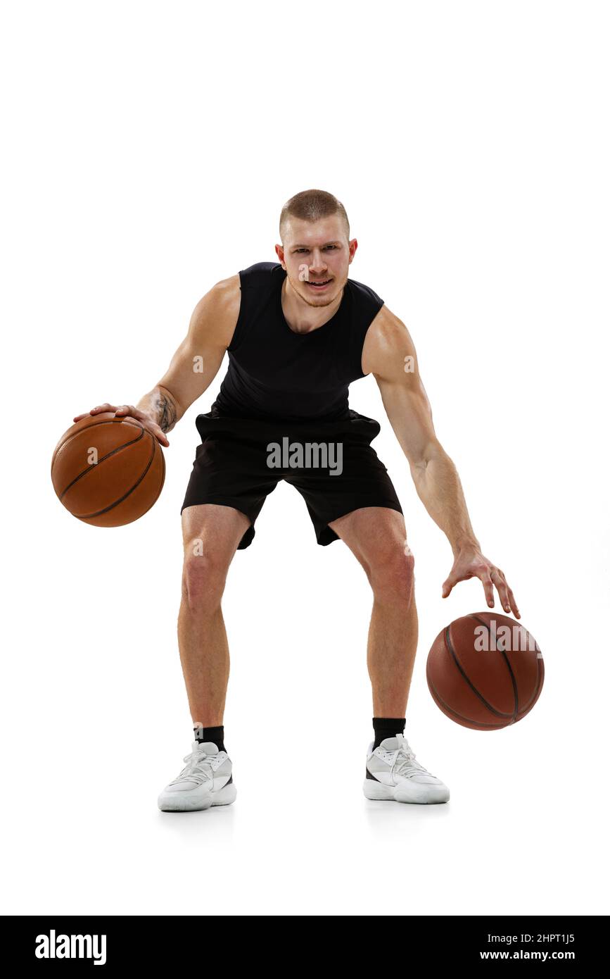 Handsome muscled man, basketball player posing with two balls isolated ...