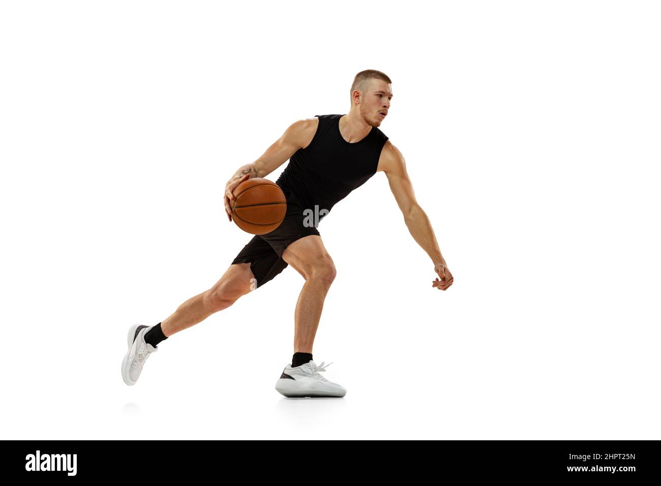 Young muscled man, basketball player practicing with ball isolated on ...