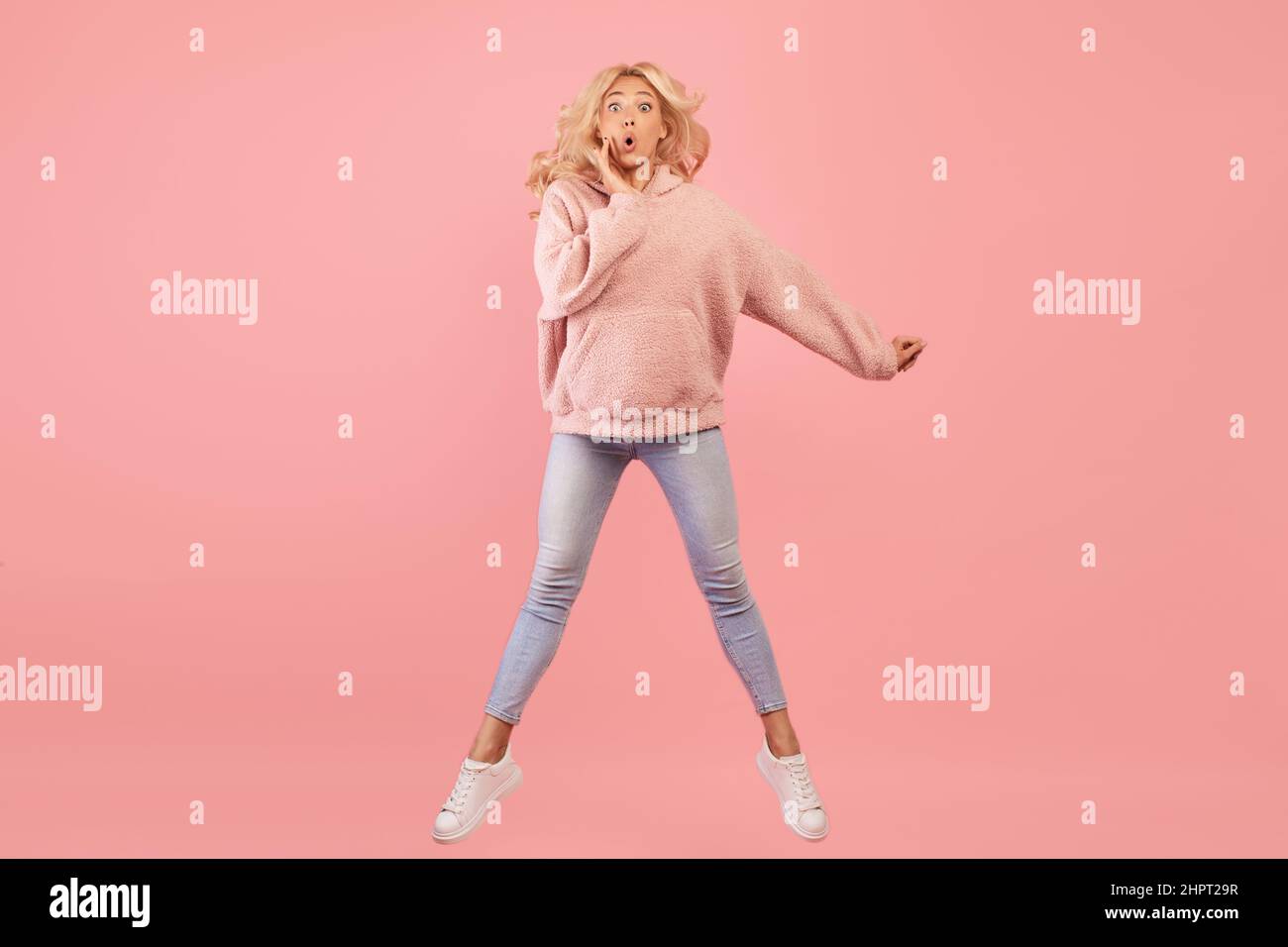 Wow. Full length portrait of surprised woman jumping, staring at camera ...
