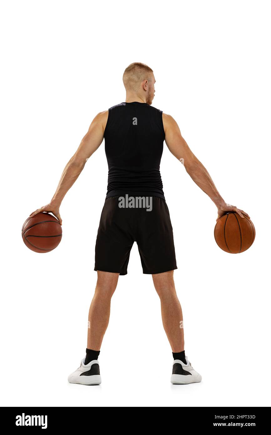 Back view of muscled man, basketball player posing with two balls ...