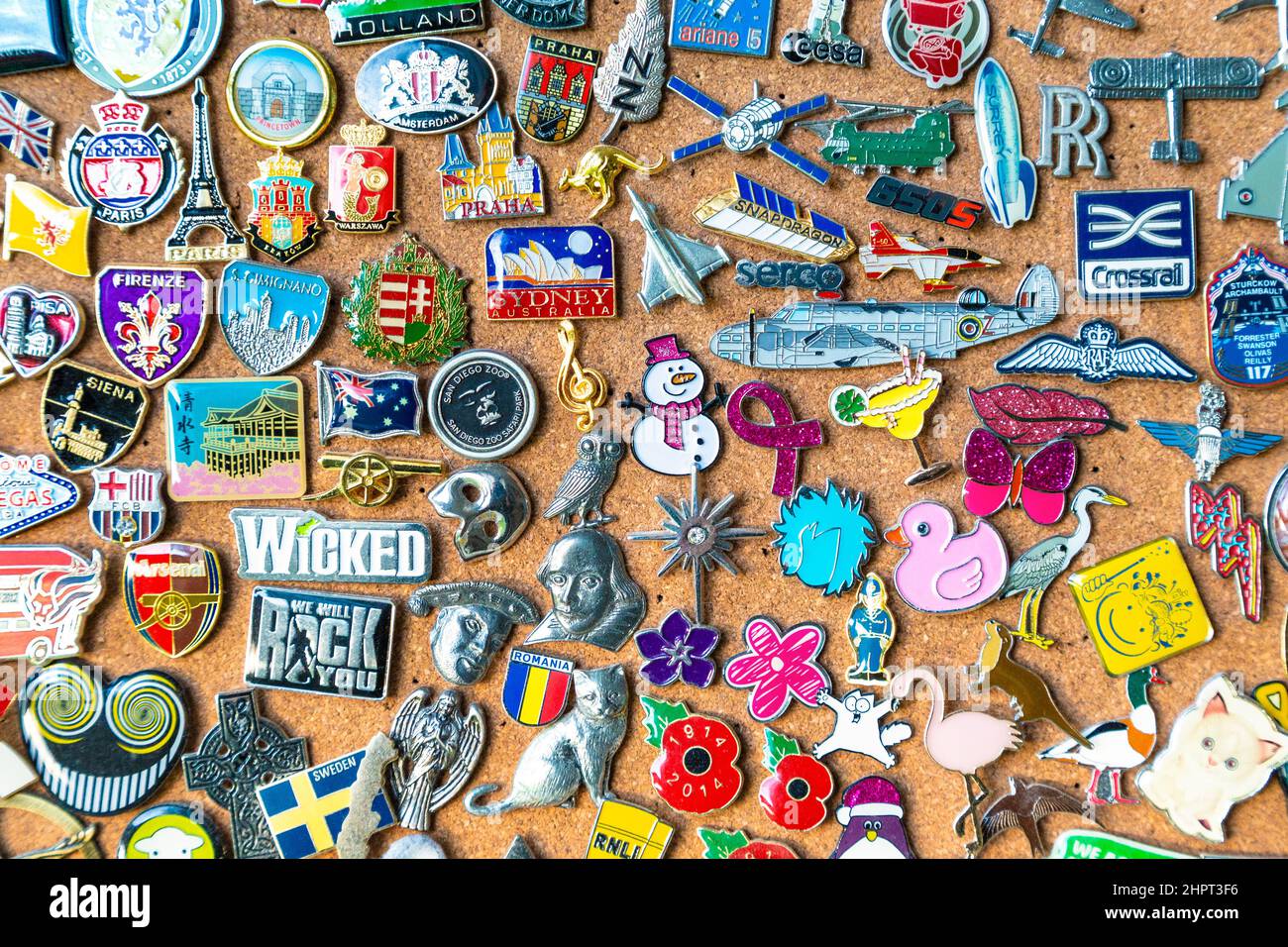 Colourful collection of pins from countries, cities, events on a cork ...