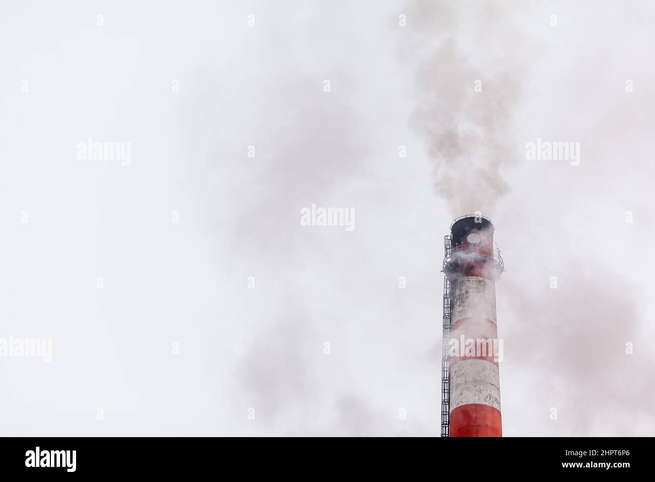 White thick smoke from the boiler room chimney. Smoke against the blue ...