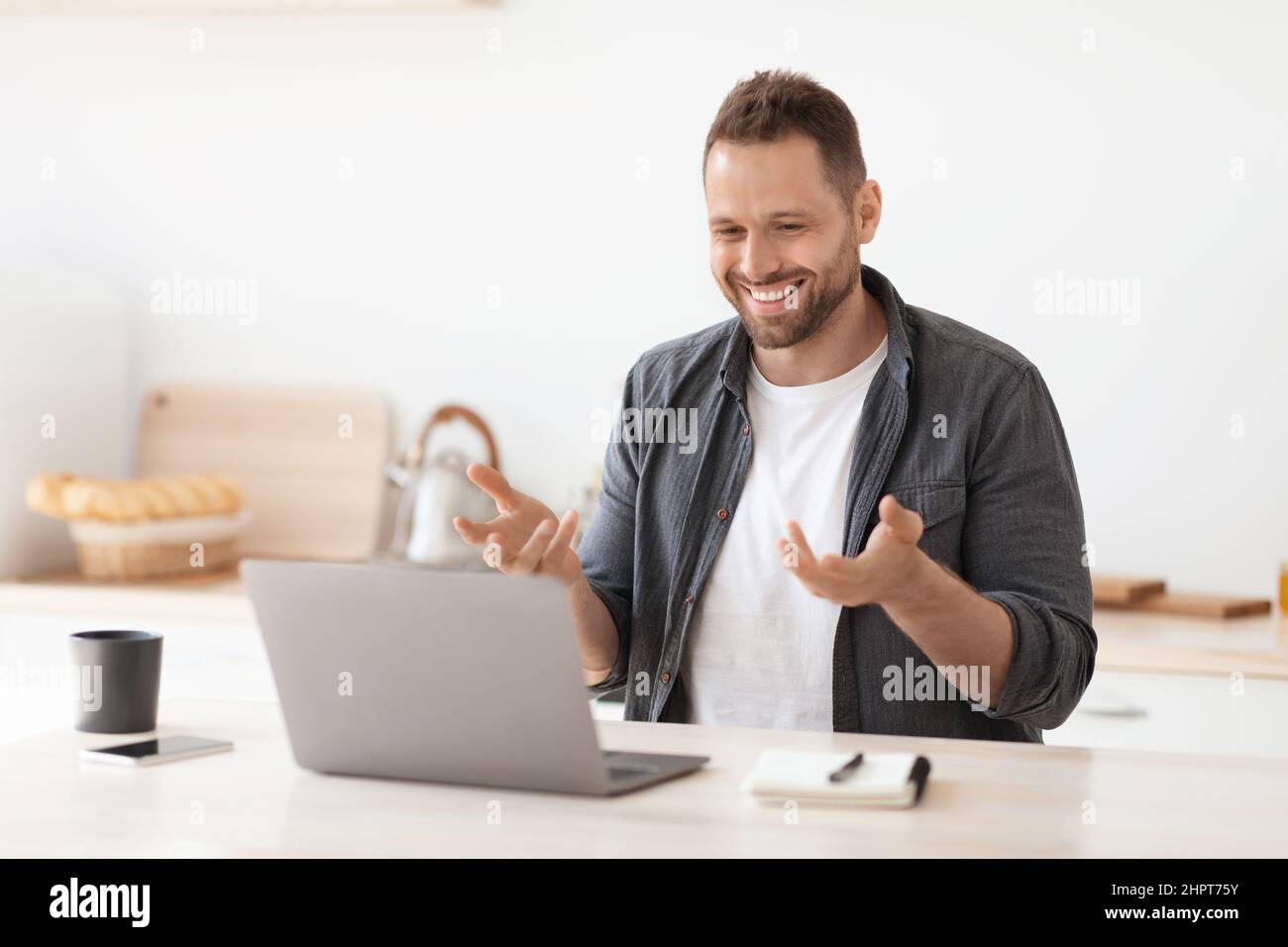 Virtual communication. Young businessman video chatting with partners ...