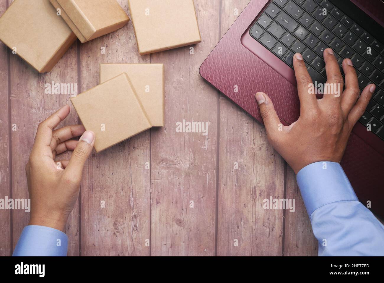 holding cardboard parcels and typing laptop on table Stock Photo - Alamy