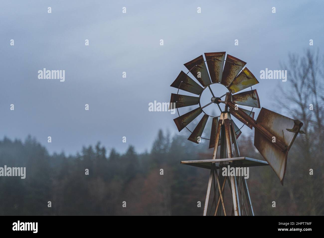 A low angle of a rusting Windmill against bleak overcast sky Stock ...