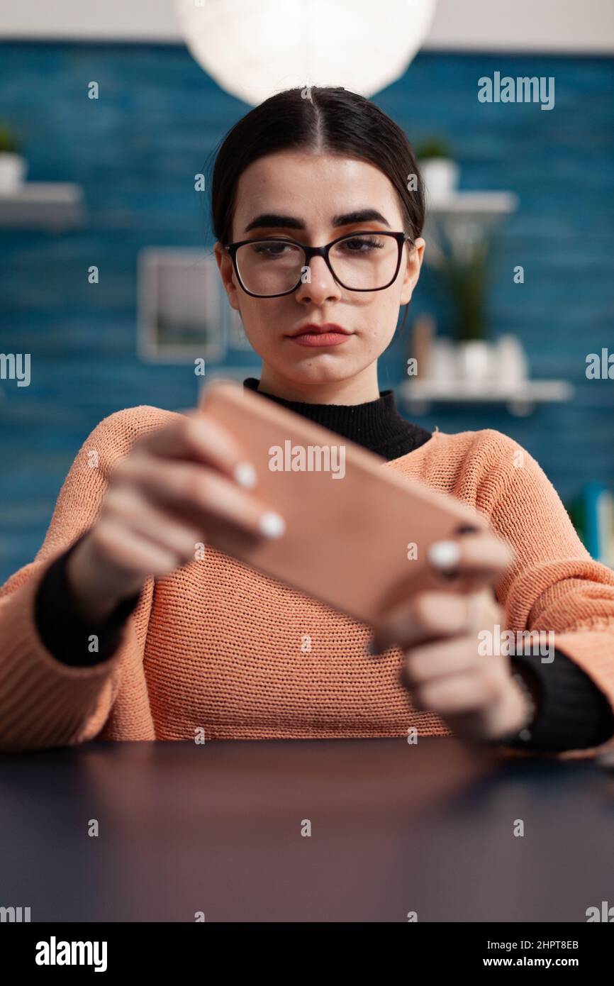 Student with glasses watching content on mobile phone display. Gamer ...