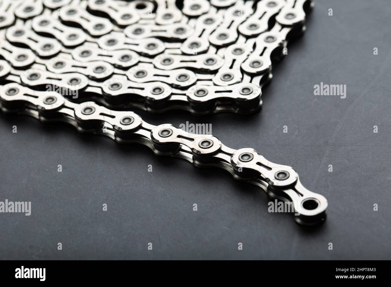 Silver chain of a road bike on a dark textured background with free ...