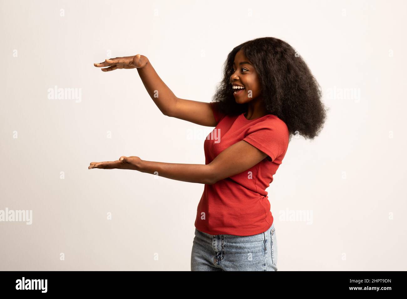 Excited Black Female Holding Big Invisible Object In Her Hands Stock ...