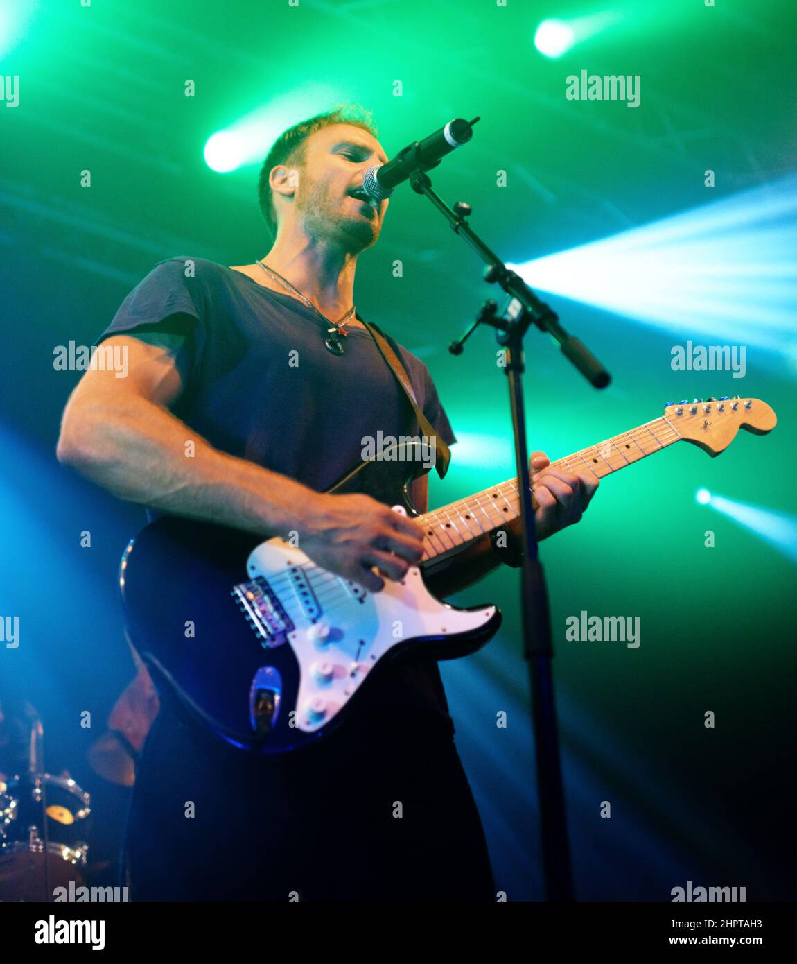 In the glorious moment. Attractive musician playing his guitar at a ...