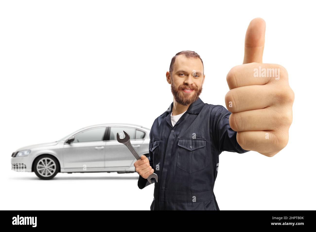 Car mechanic gesturing thumbs up and holding a wrench isolated on white ...