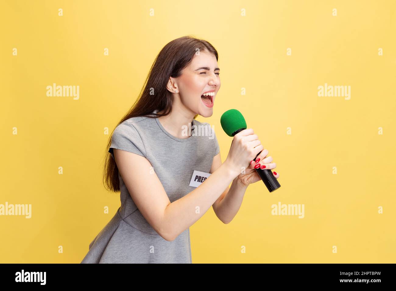 Emotional young girl, female reporter holding reporter microphone ...