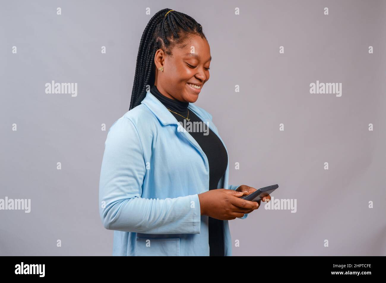 Beautiful African woman using a calculator for calculations on white ...
