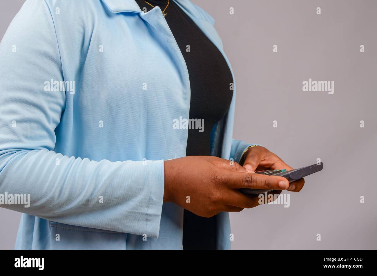 Beautiful African woman using a calculator for calculations on white ...