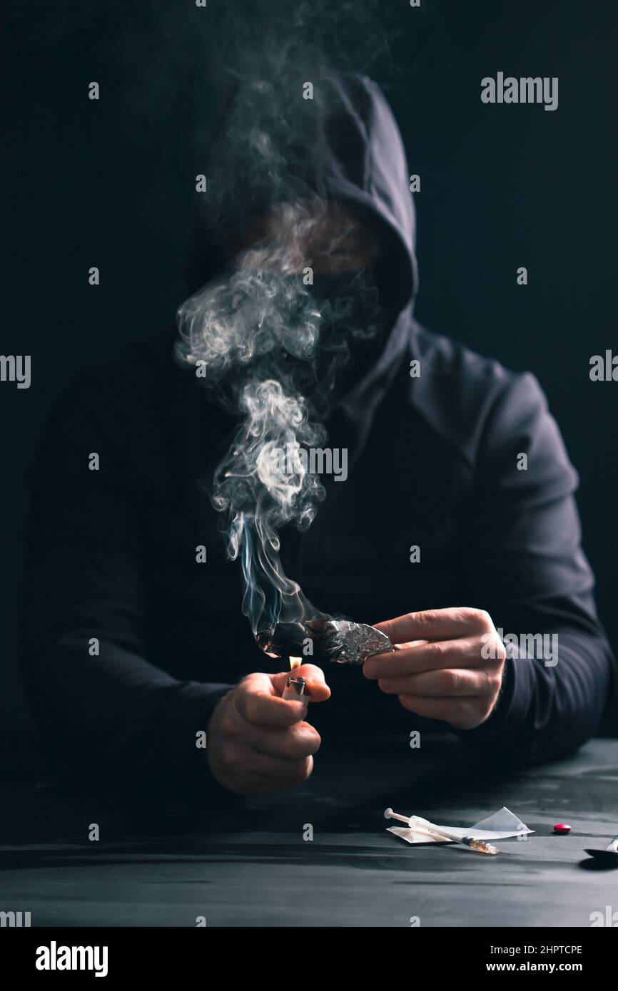 Addict/junkie man preparing drugs. The concept of crime and drug ...